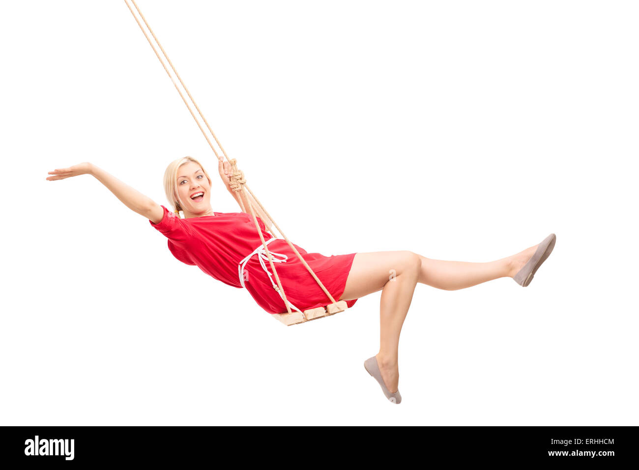 Joyful woman swinging on a swing and gesturing with her hands isolated ...