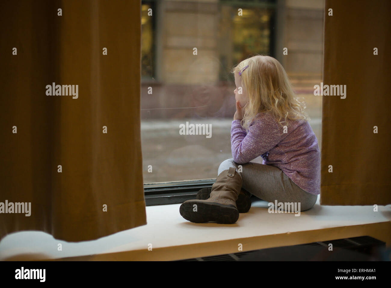 Girl looking out of a window Stock Photo - Alamy