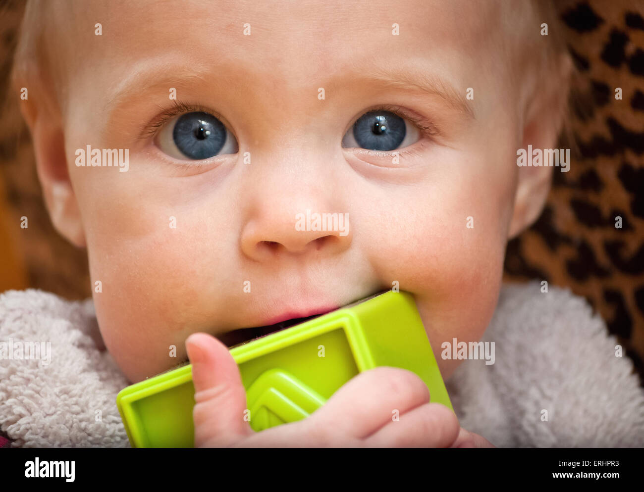 Baby holding a green block facing camera Stock Photo - Alamy