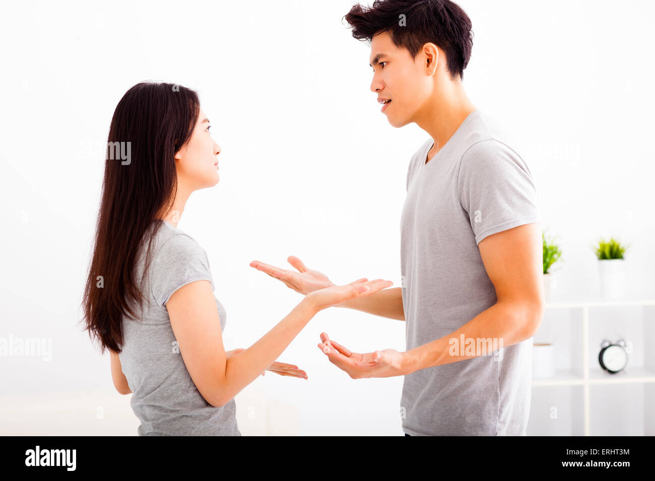 Angry young couple arguing in living room Stock Photo - Alamy