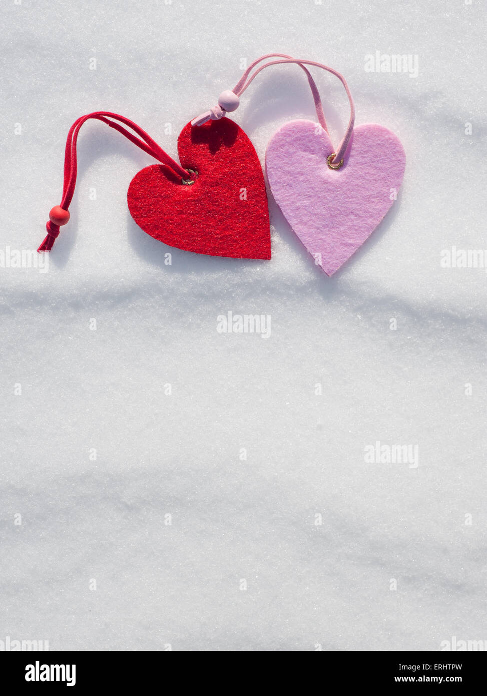 two hearts on snow background Stock Photo - Alamy