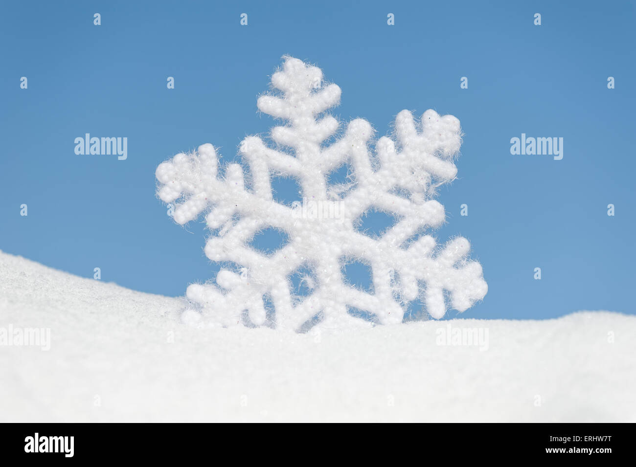big snowflake in snow on sky background Stock Photo - Alamy