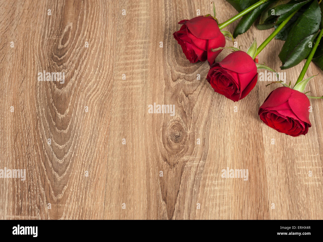three red roses on wood Stock Photo - Alamy