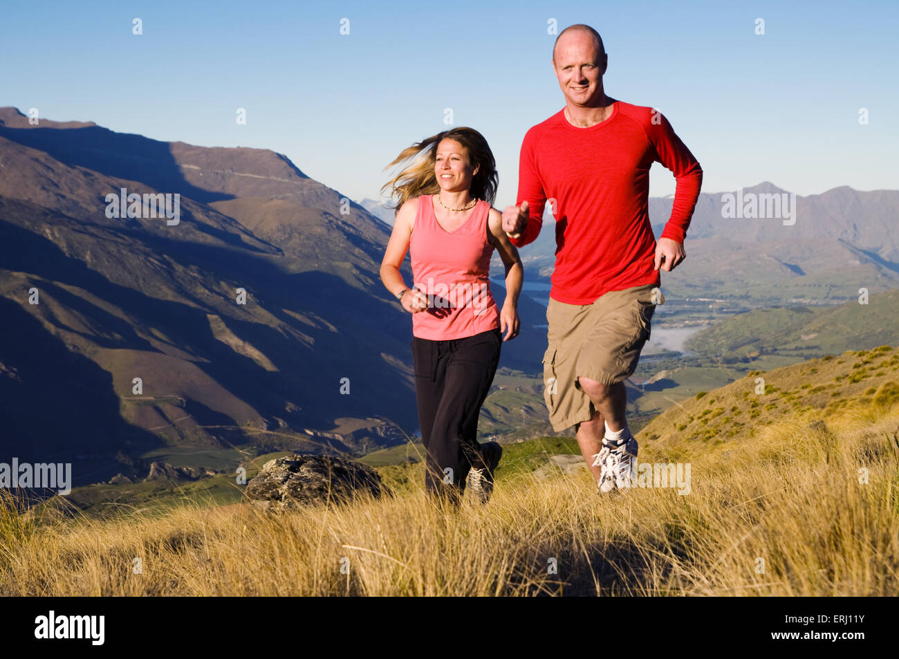 Couple jogging together in a beautiful mountain scenic Stock Photo - Alamy