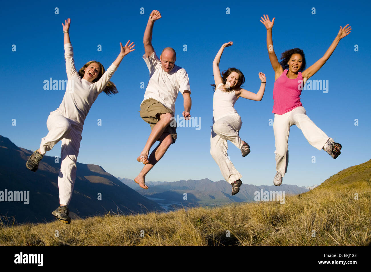 Group of young people jumping in the field Stock Photo - Alamy