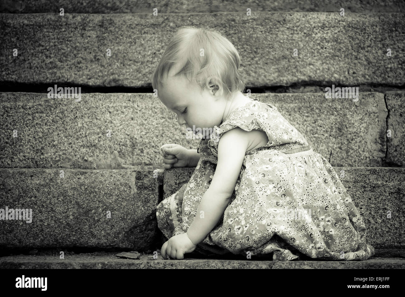 Cute Little baby find something on the ground - outdoors. B&W version ...