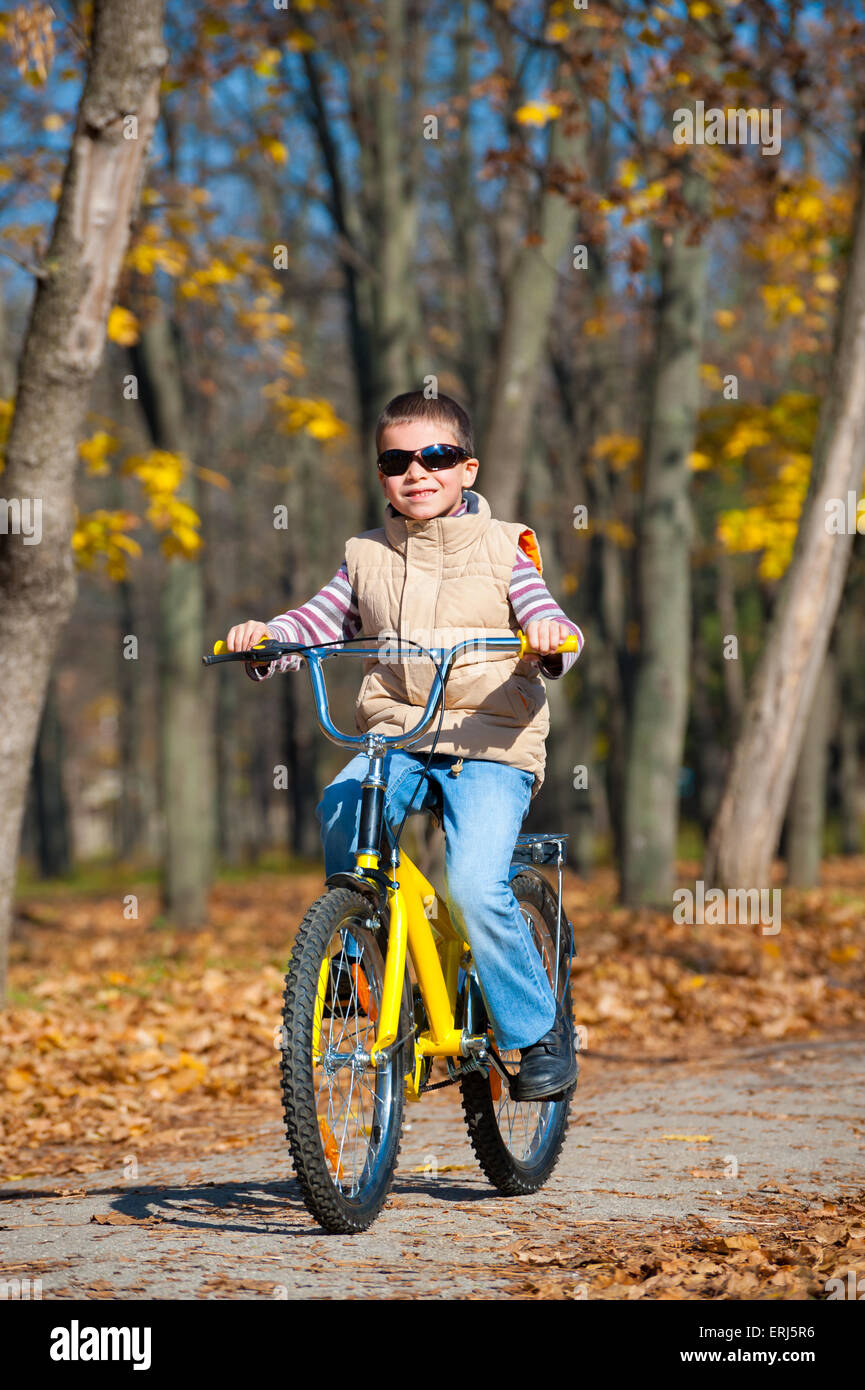 boy rides a bicycle in autumn park Stock Photo - Alamy