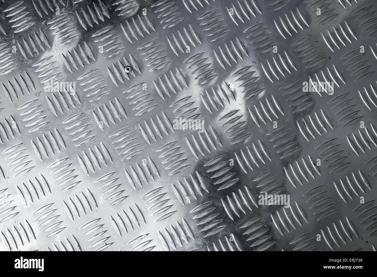 Dark gray shining metal floor surface with industrial diamond plate ...