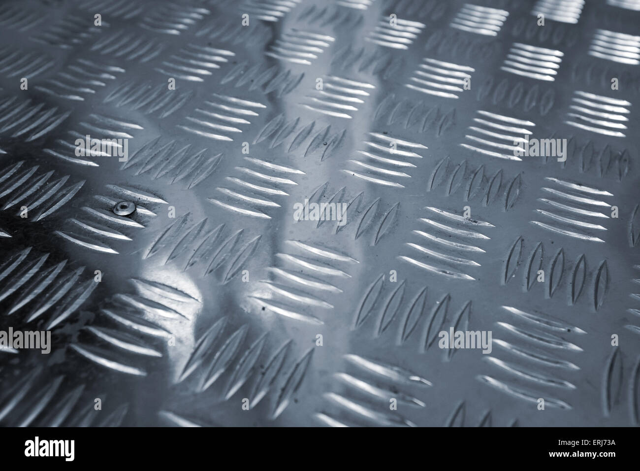 Blue shining metal floor surface with industrial diamond plate relief ...