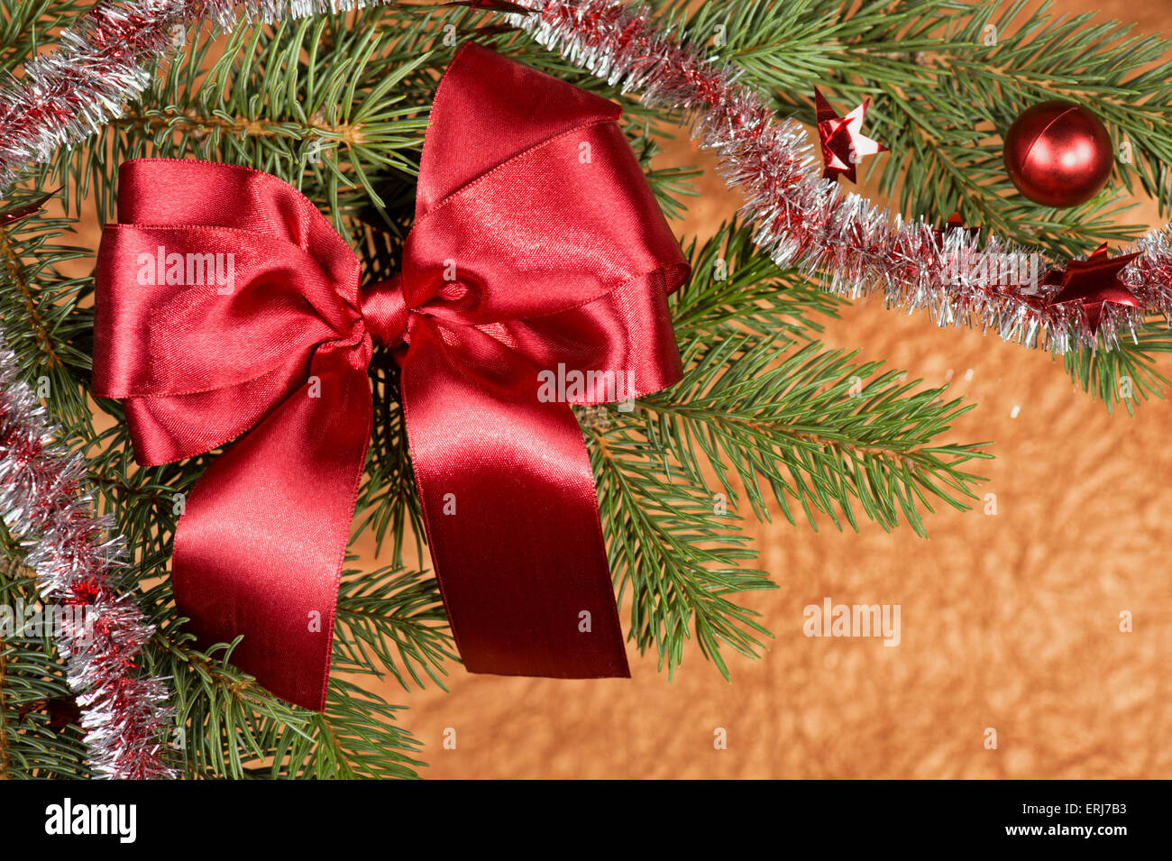 fir branches with red bow on golden background Stock Photo - Alamy