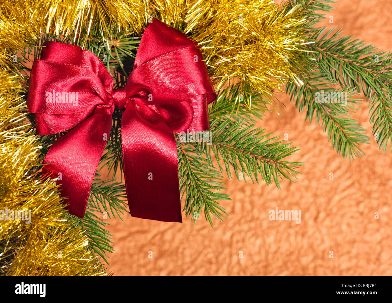 fir branches with red bow on golden background Stock Photo - Alamy