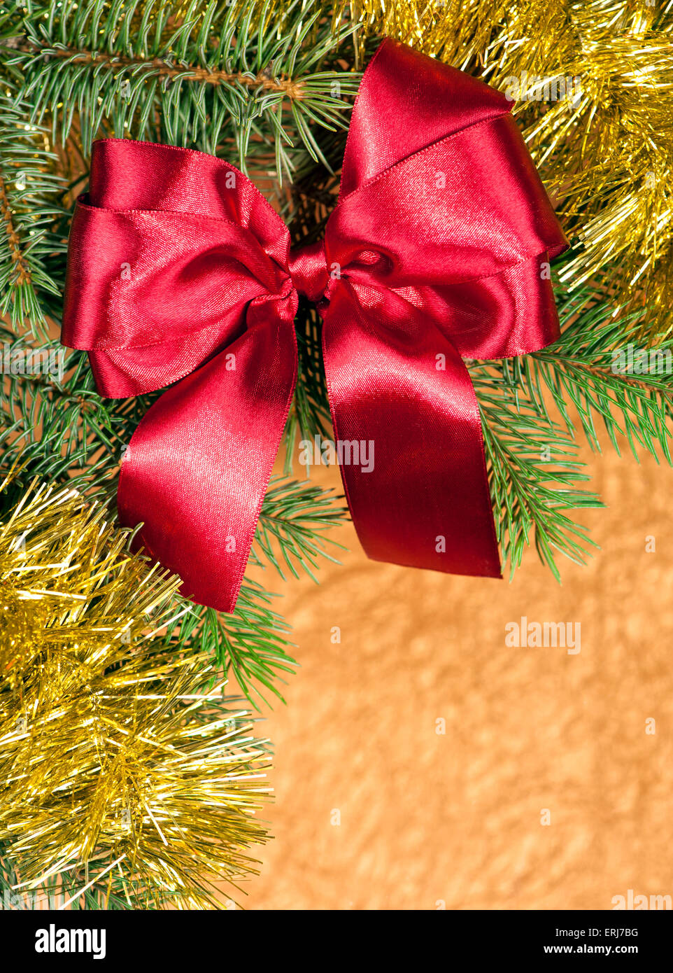 fir branches with red bow on golden background Stock Photo - Alamy