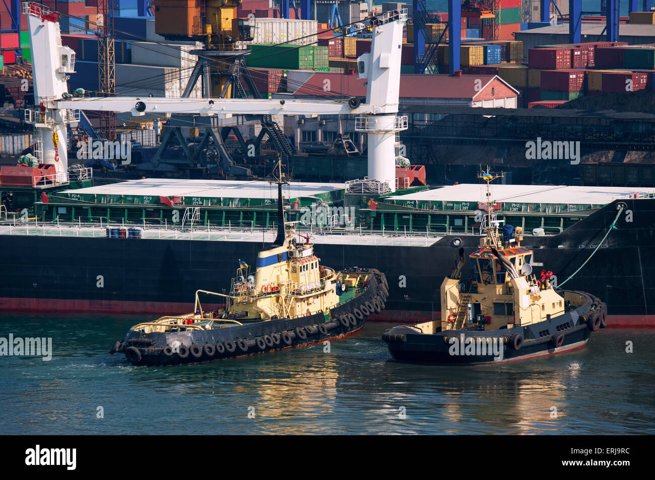 cargo ship and tug boat in industrial port Stock Photo - Alamy