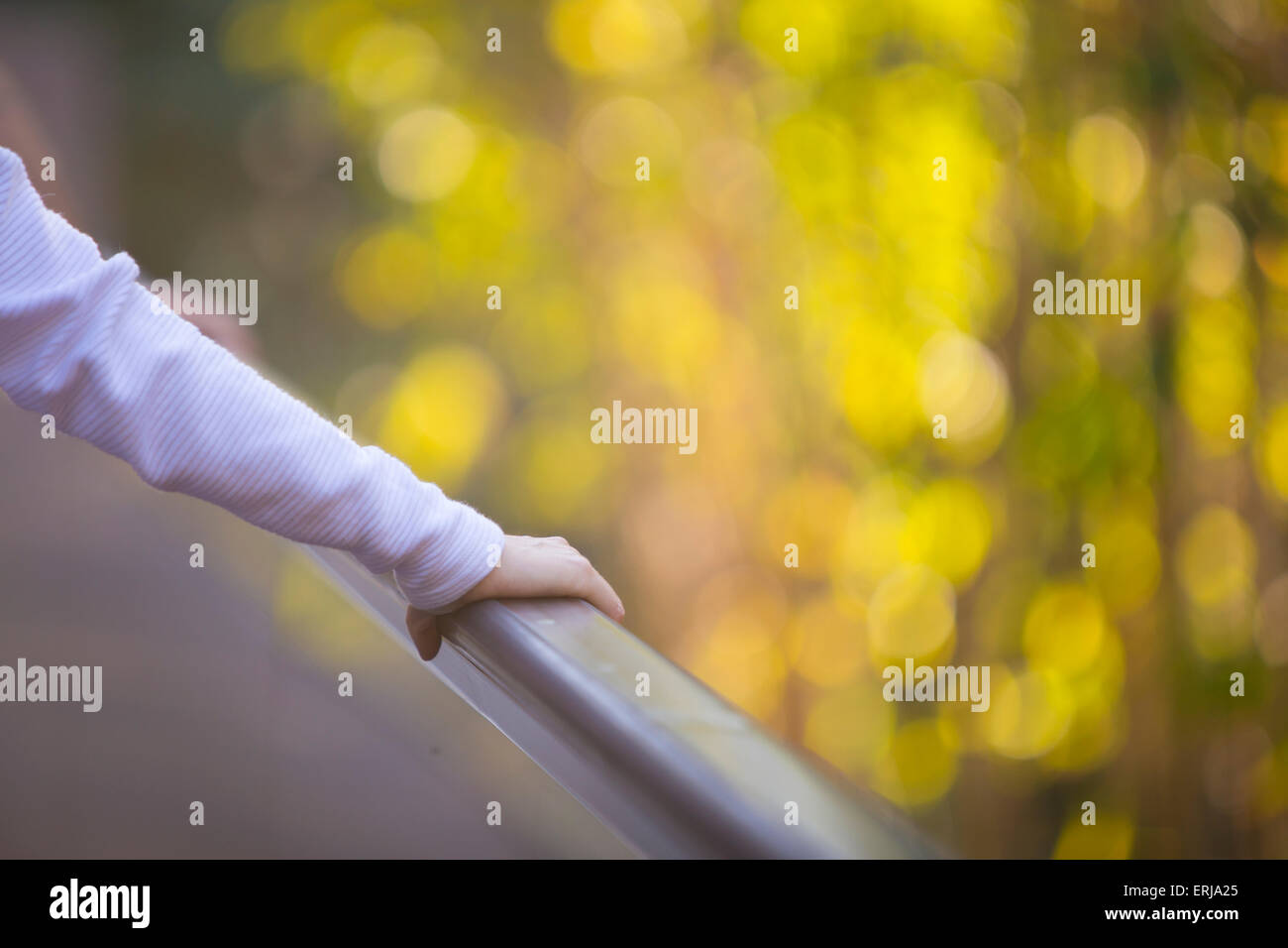 Woman holding handrail on an escalator Stock Photo - Alamy