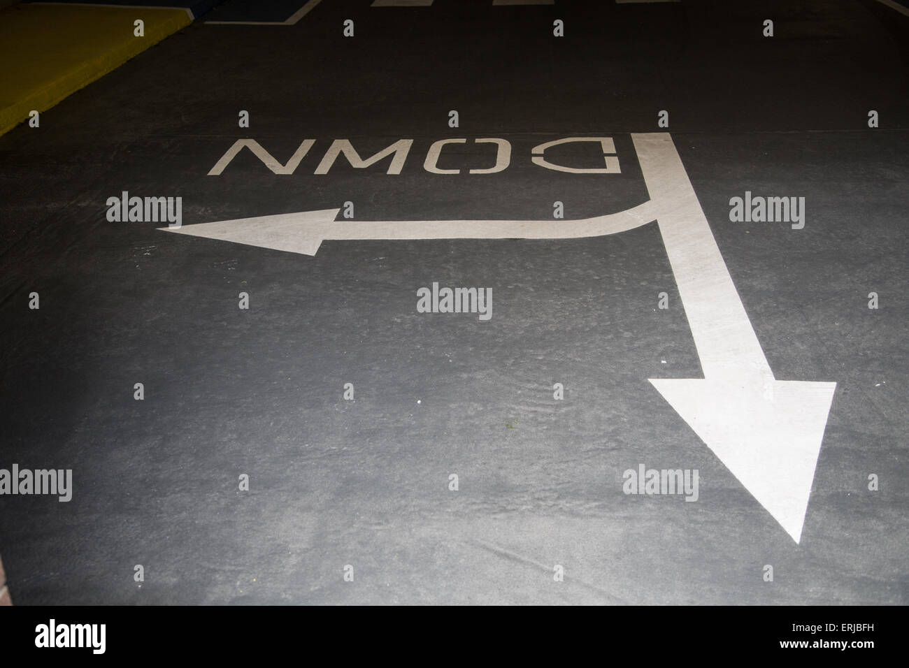 Down sign painted on multistorey car park floor Stock Photo - Alamy