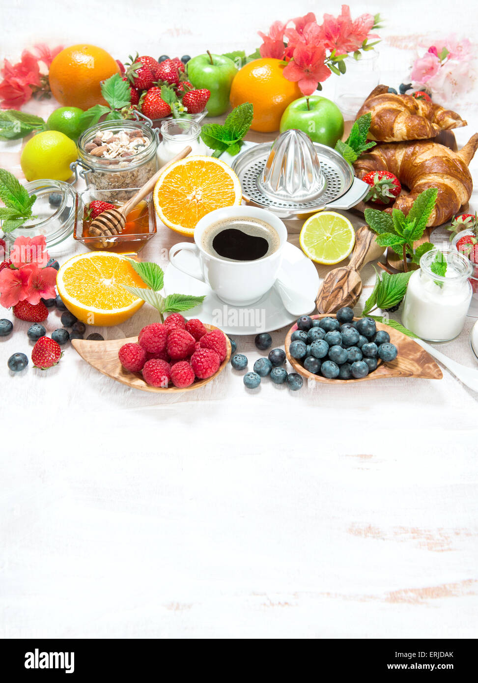 Breakfast table setting with coffee, croissants, cereal granola, honey ...