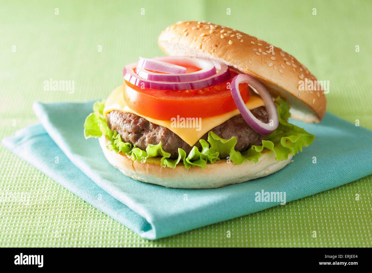 burger with beef patty cheese lettuce onion tomato Stock Photo - Alamy