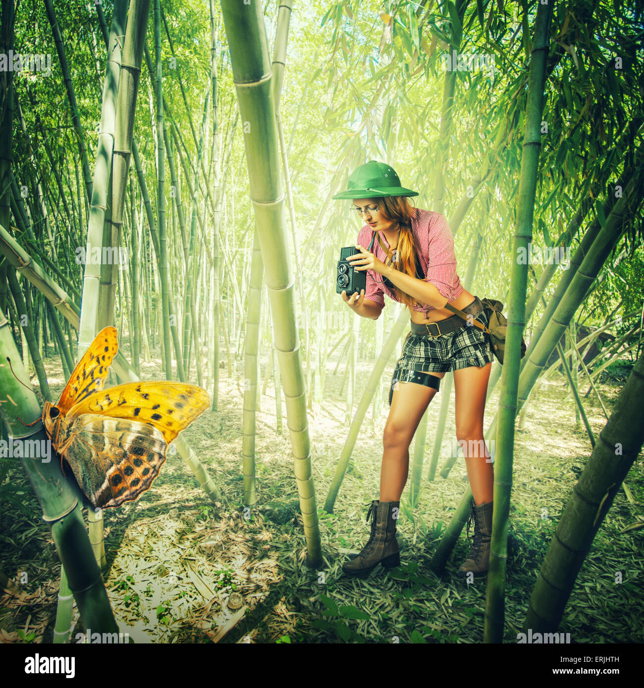 Young retro styled woman traveler in tropics holding vintage camera ...