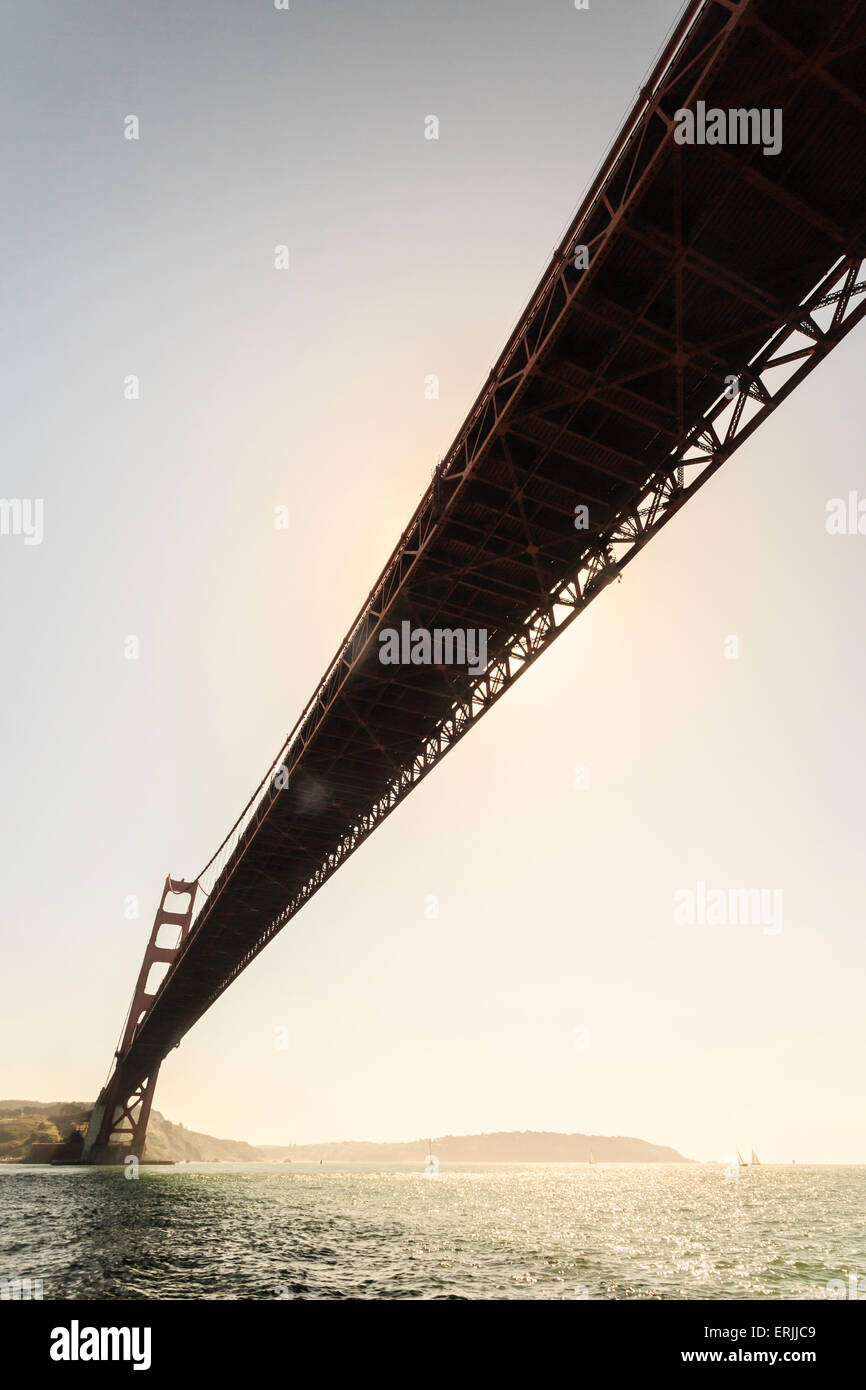 Long span of underside of golden gate bridge viewed from boat in waters ...