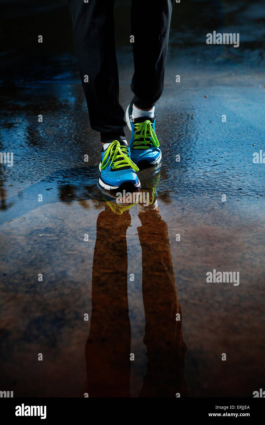 Single runner running in rain Stock Photo - Alamy