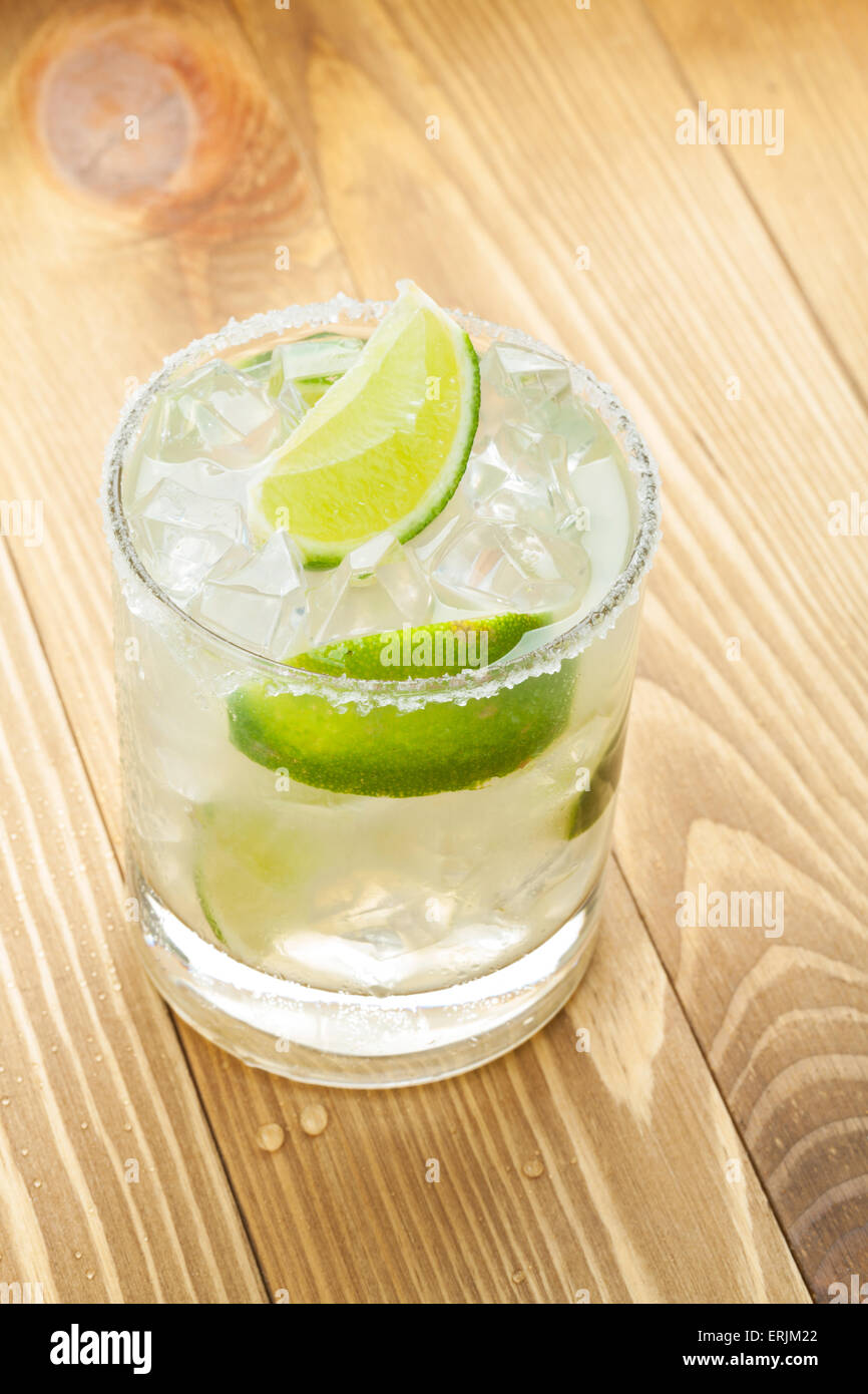 Classic margarita cocktail with salty rim on wooden table Stock Photo ...