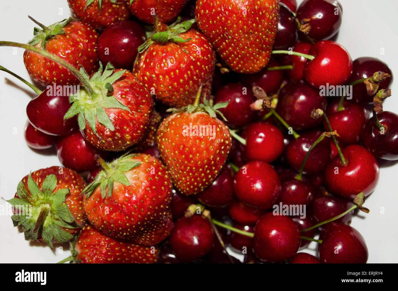 Bright background of strawberries and red cherries on white background ...