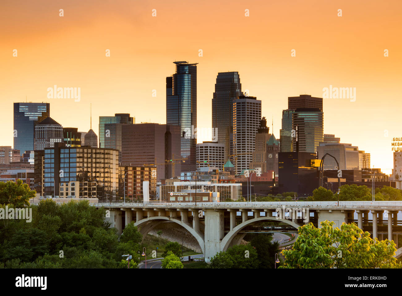 Minneapolis skyline and Tenth Avenue bridge with orange storm light ...