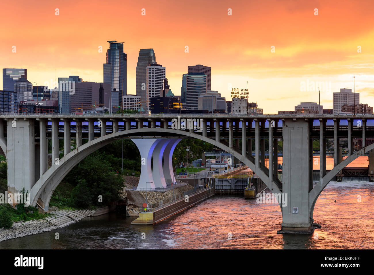 Minneapolis skyline and Tenth Avenue bridge with orange storm light ...