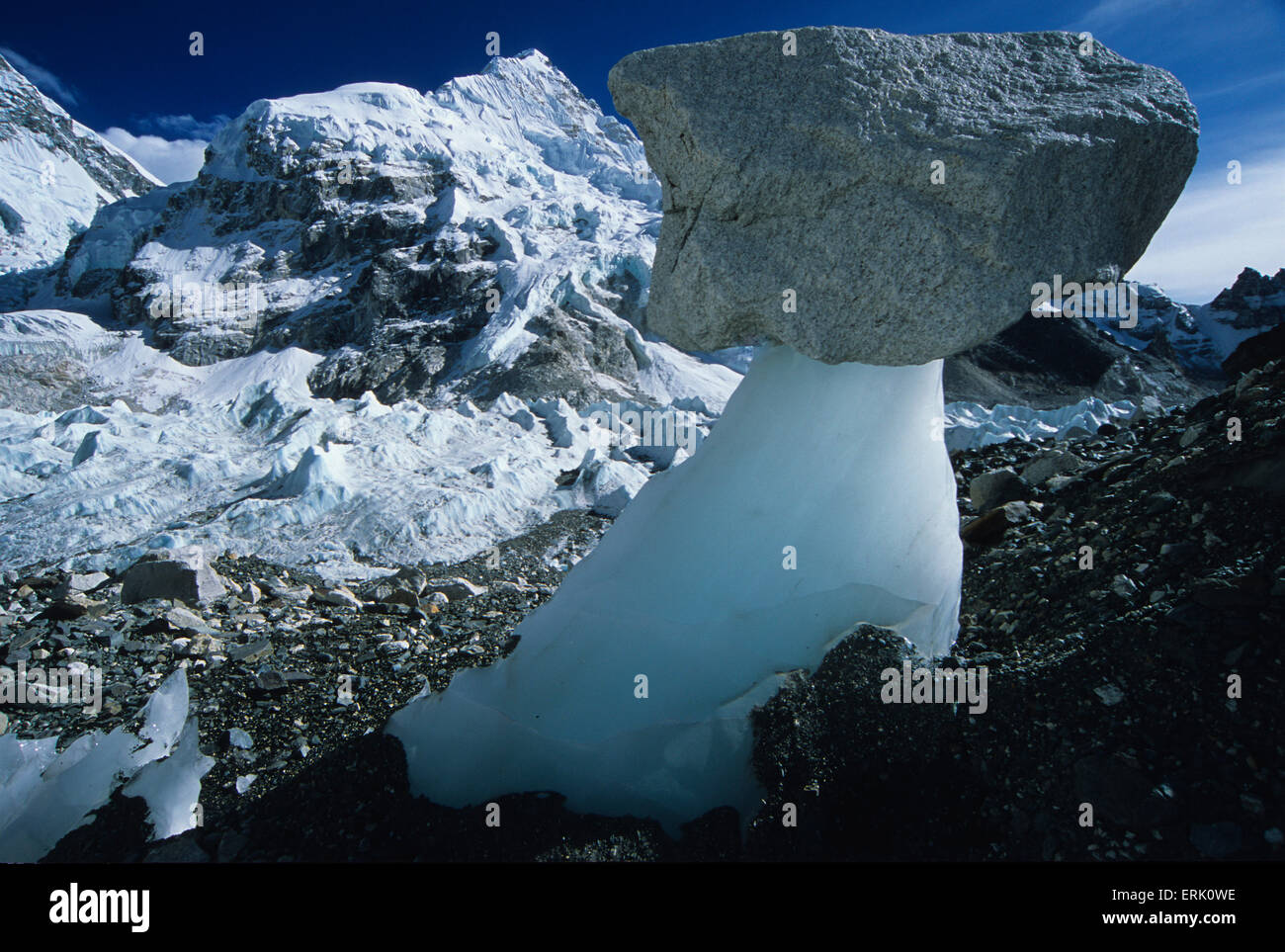 A large granite boulder sits atop a melting stand of ice at basecamp ...
