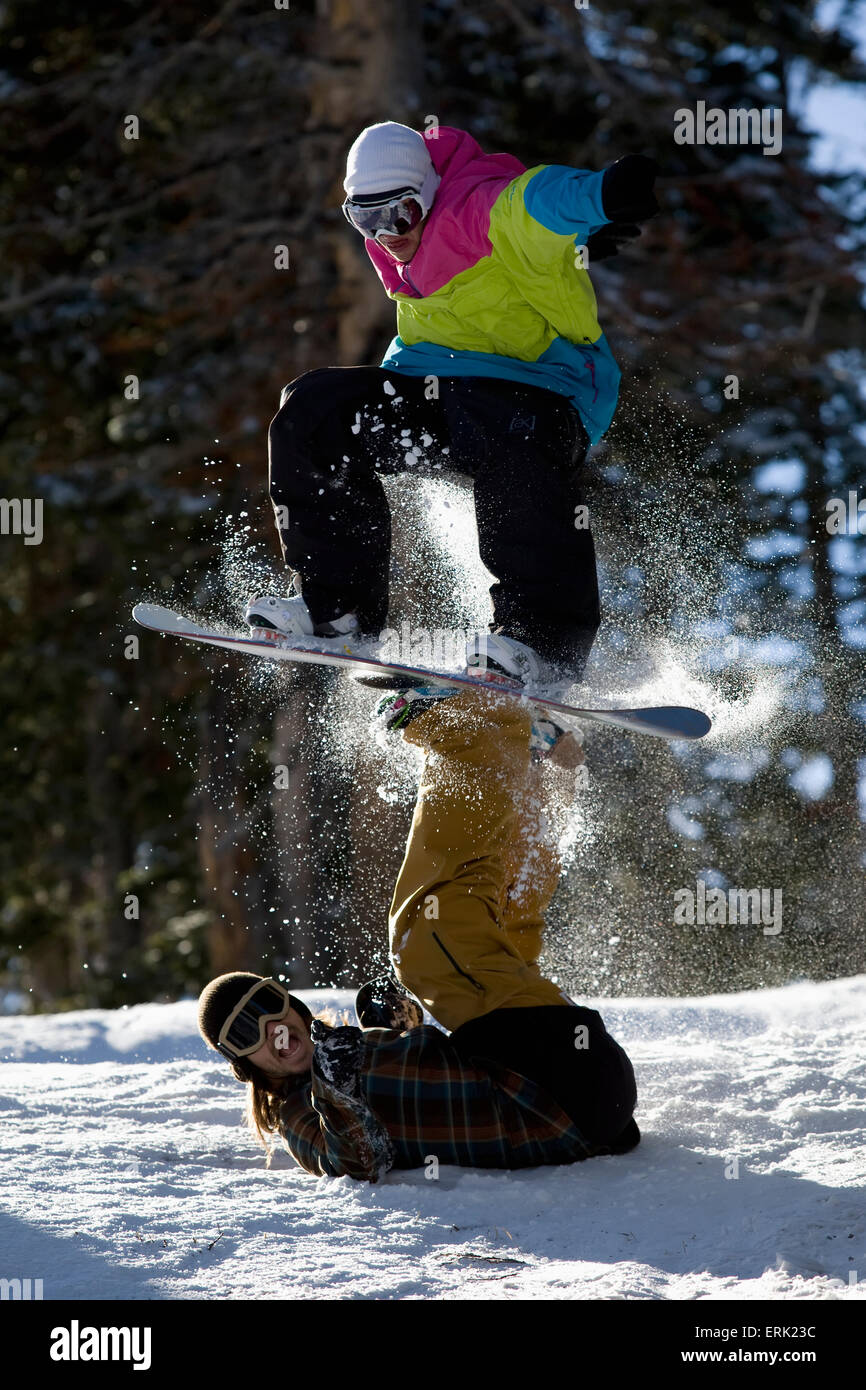 Two snowboarders have fun doing a balance trick in the snow; Utah ...
