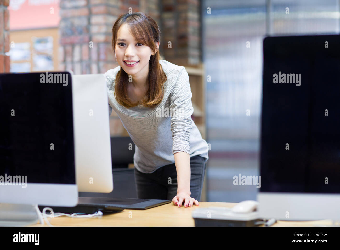 Young woman using computer in office Stock Photo - Alamy