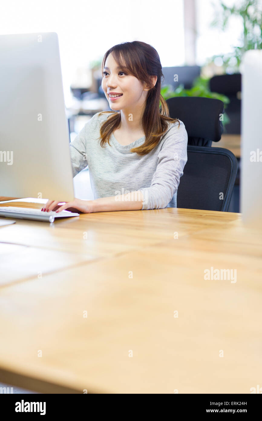 Young woman using computer in office Stock Photo - Alamy