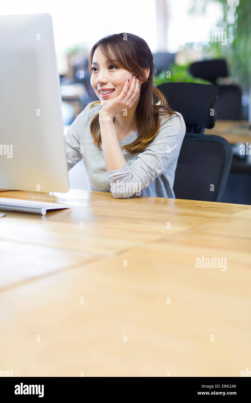 Young woman using computer in office Stock Photo - Alamy
