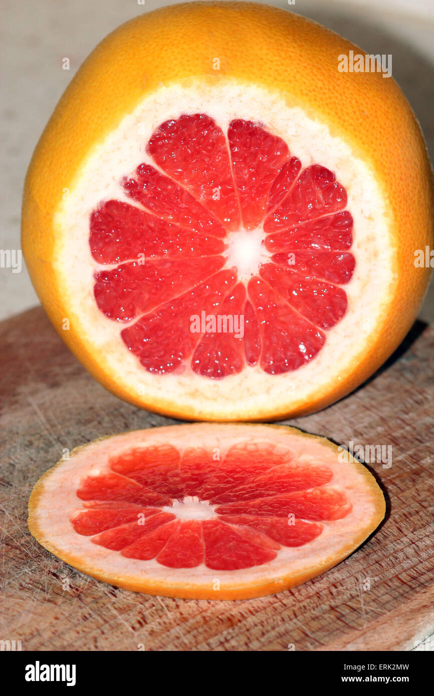 cut fruit of red grapefruit on the board Stock Photo - Alamy