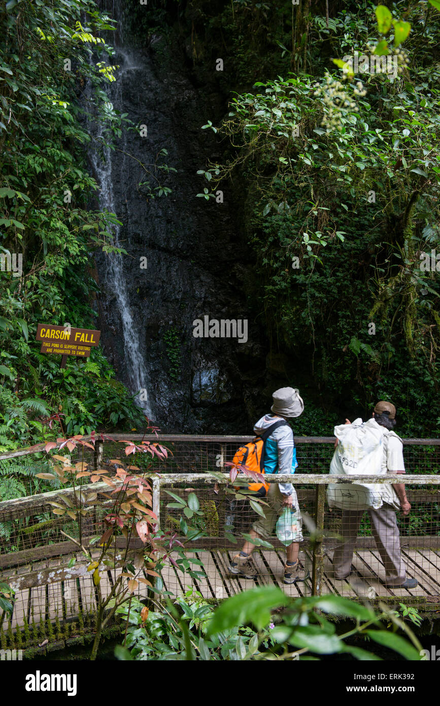 Girl and guide looking at waterfall while crossing bridge, Mount ...