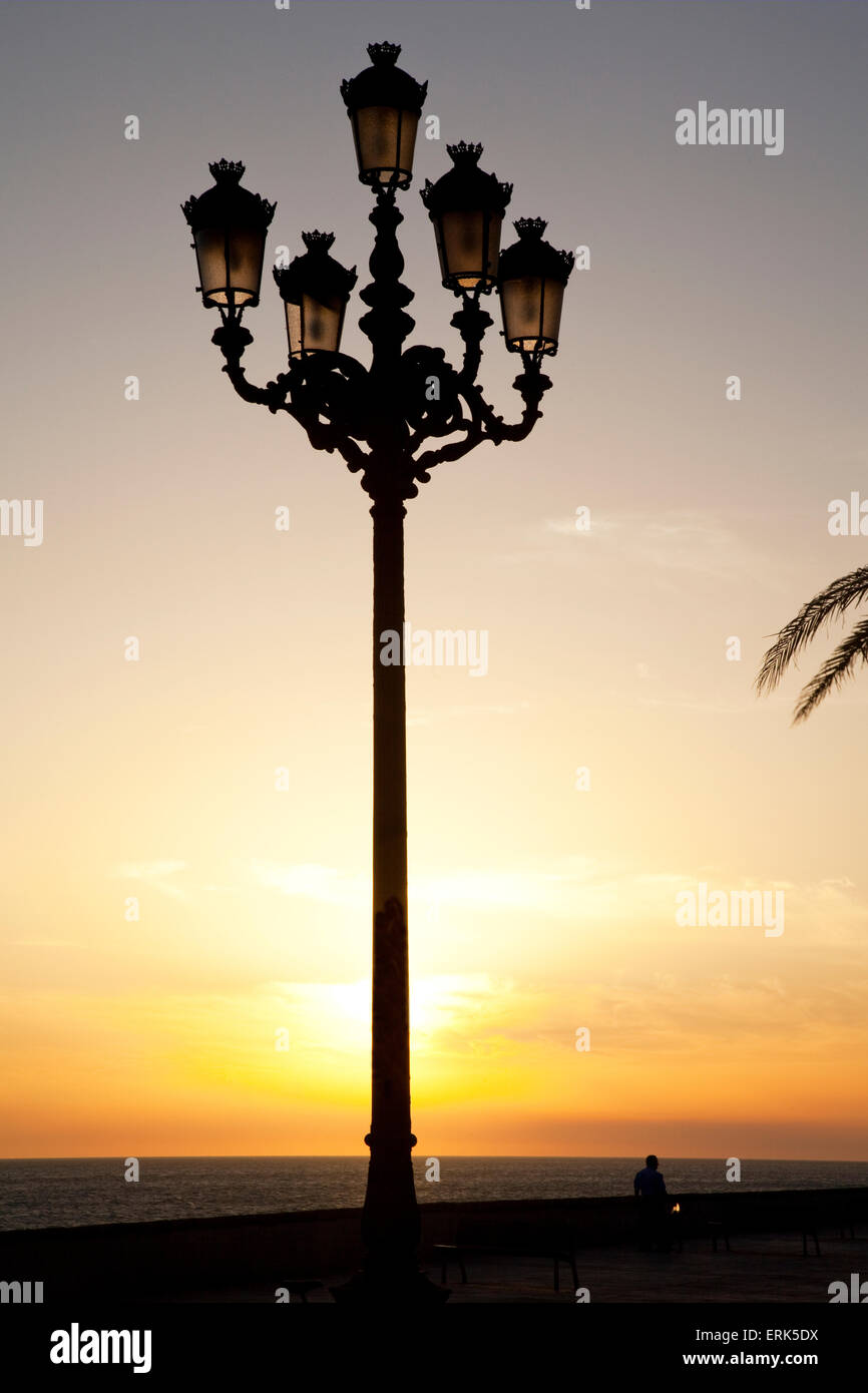 Lamppost at the beach with a glowing sunset; Cadiz de la Frontera ...