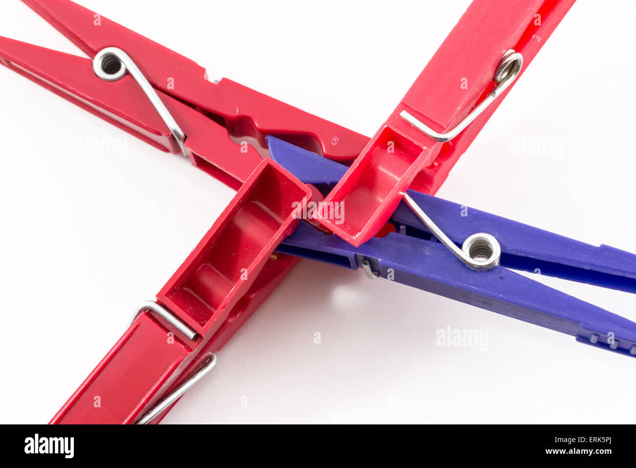 Three red pegs attacking and biting a blue plastic peg Stock Photo - Alamy