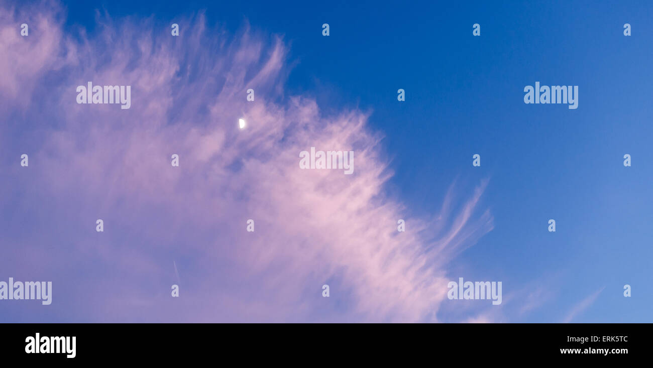 Wisps of cloud at sunset and a half moon Stock Photo - Alamy
