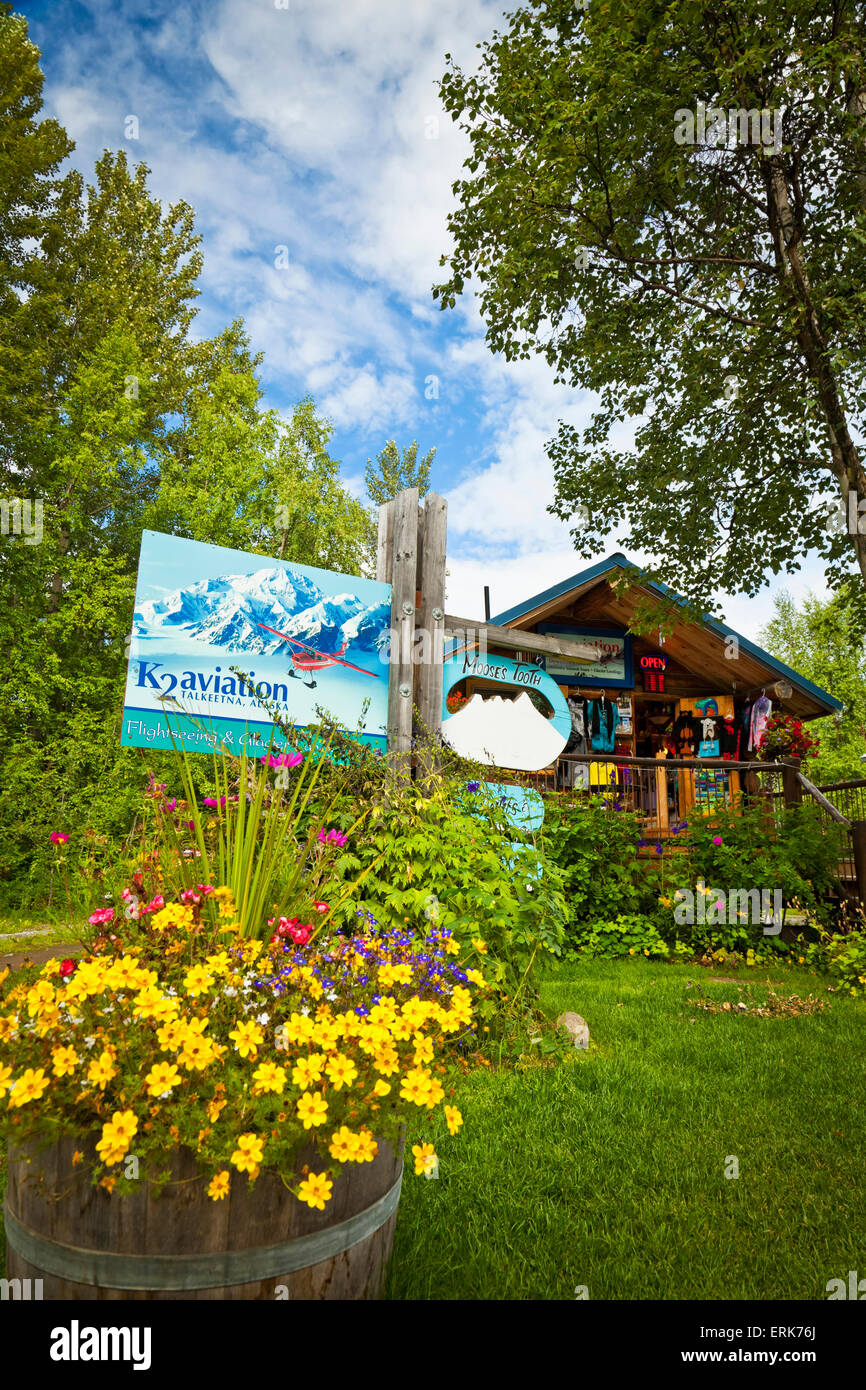 Rustic log cabin building of K2 Aviation surrounded by flower pots ...