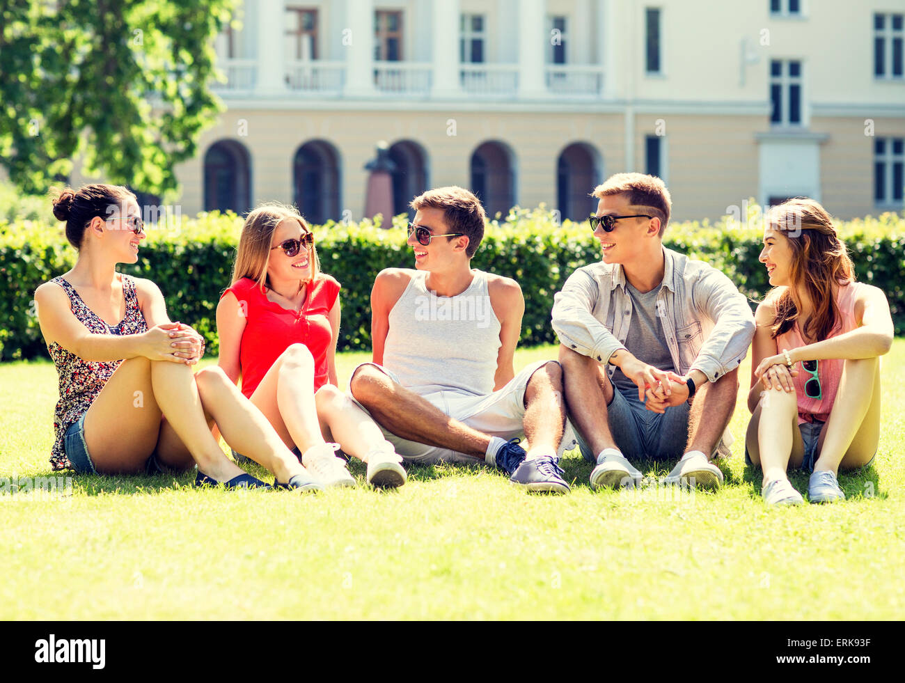 group of smiling friends outdoors sitting on grass Stock Photo - Alamy