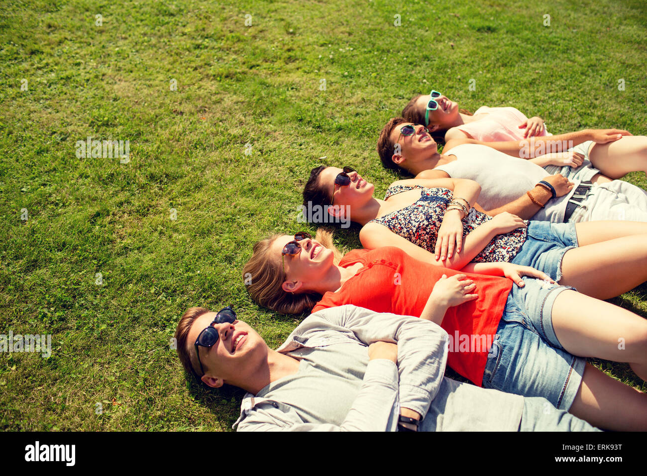 group of smiling friends lying on grass outdoors Stock Photo - Alamy