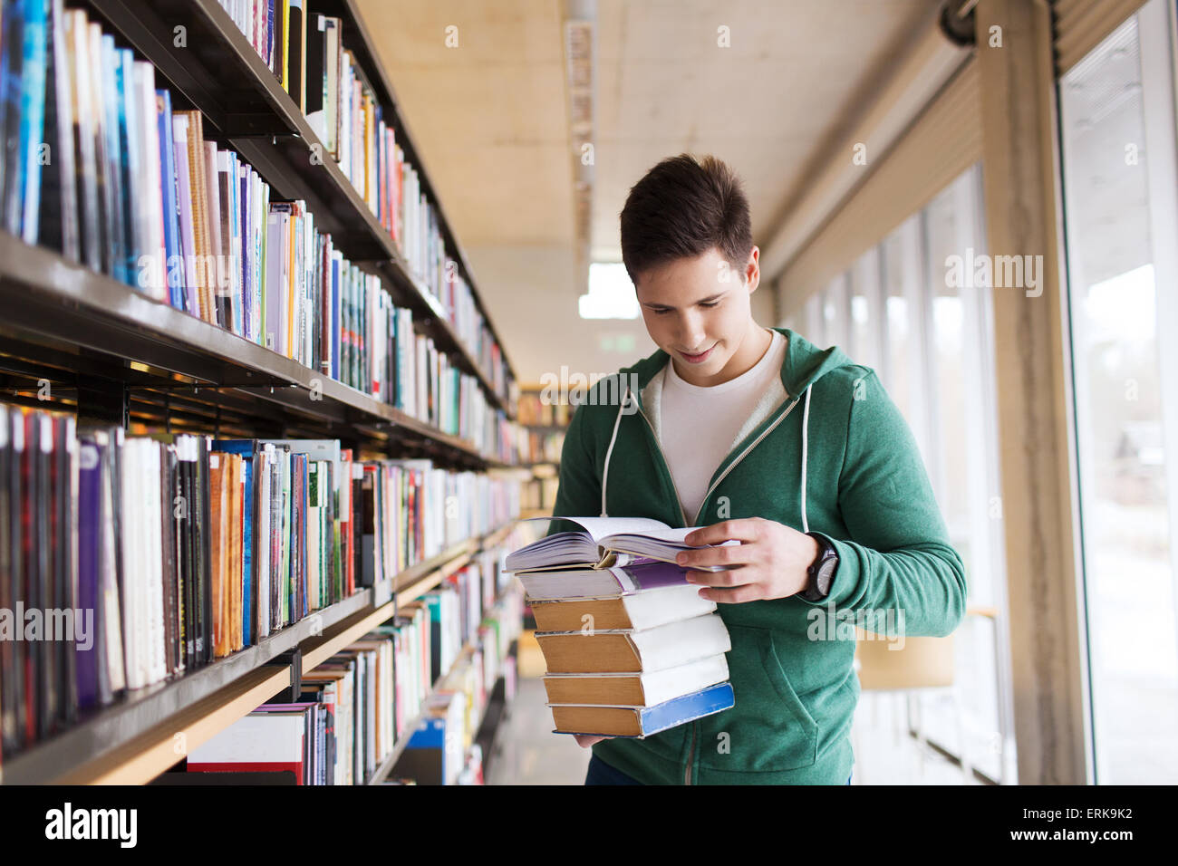happy student or man with book in library Stock Photo - Alamy