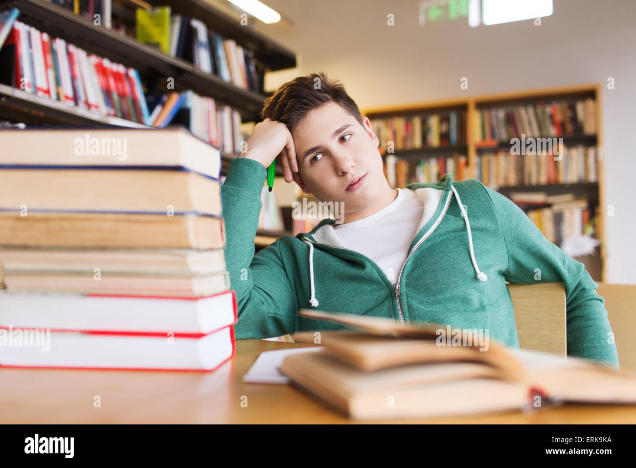 bored student or young man with books in library Stock Photo - Alamy