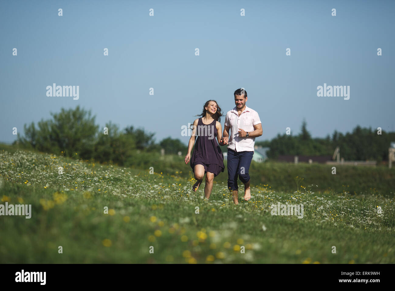 Couple running in field and have fun Stock Photo - Alamy