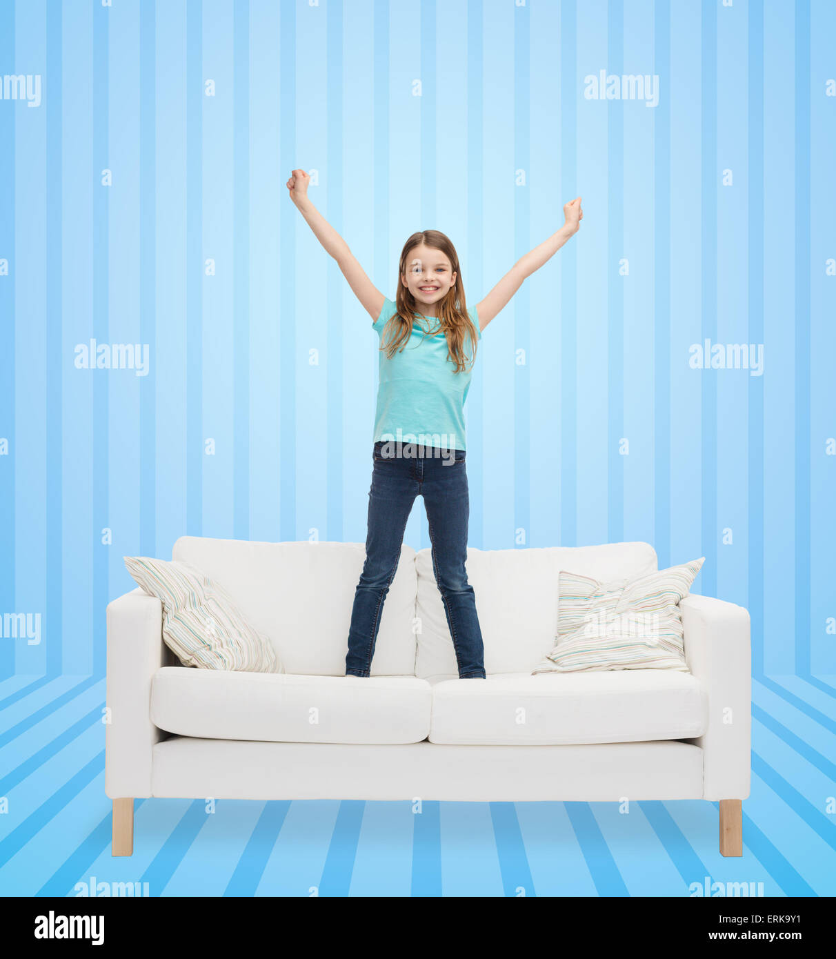 smiling little girl jumping on sofa Stock Photo - Alamy