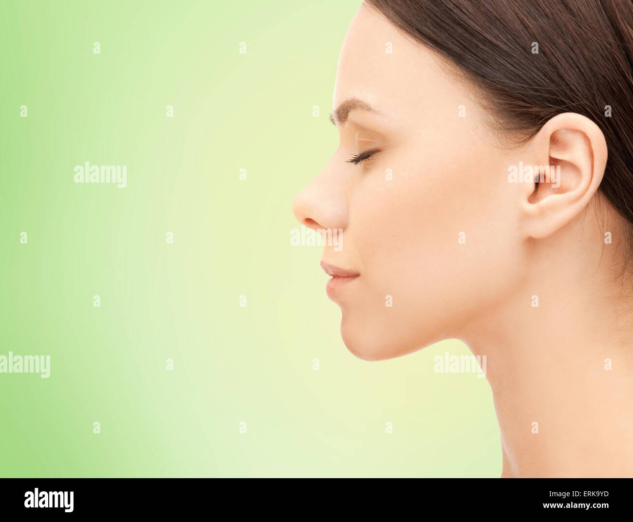beautiful young woman face over green background Stock Photo - Alamy