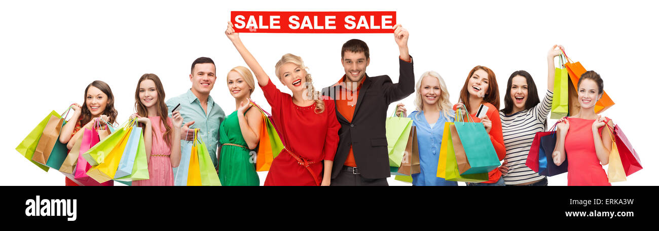happy people with red sale sign and shopping bags Stock Photo - Alamy