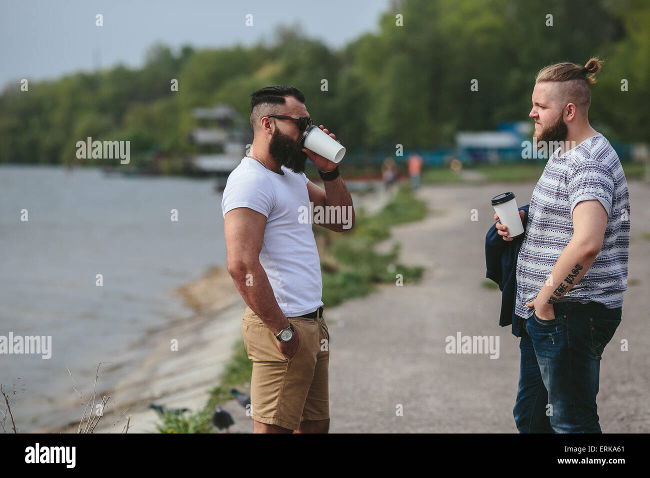 Two men stand and drink coffee Stock Photo - Alamy