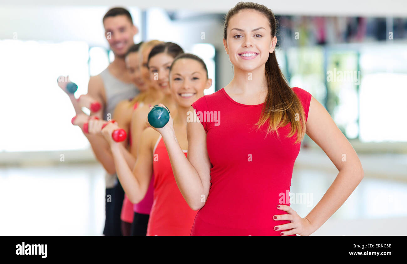 group of smiling people with dumbbells in the gym Stock Photo - Alamy