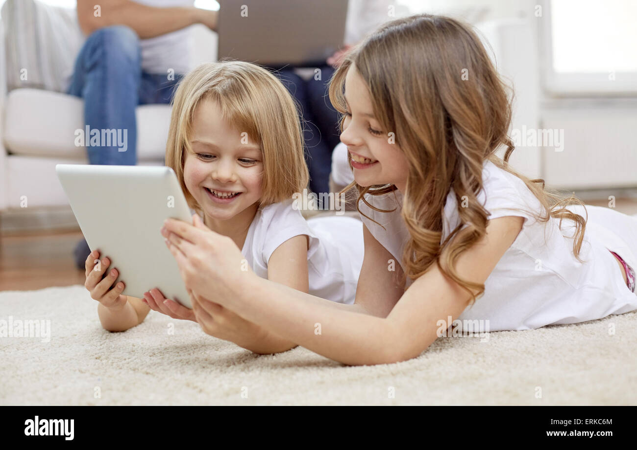 happy little girls with tablet pc computer at home Stock Photo - Alamy